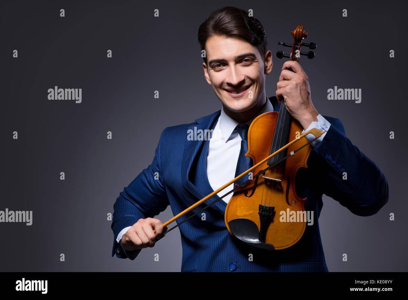Young man playing violin in dark room Stock Photo - Alamy
