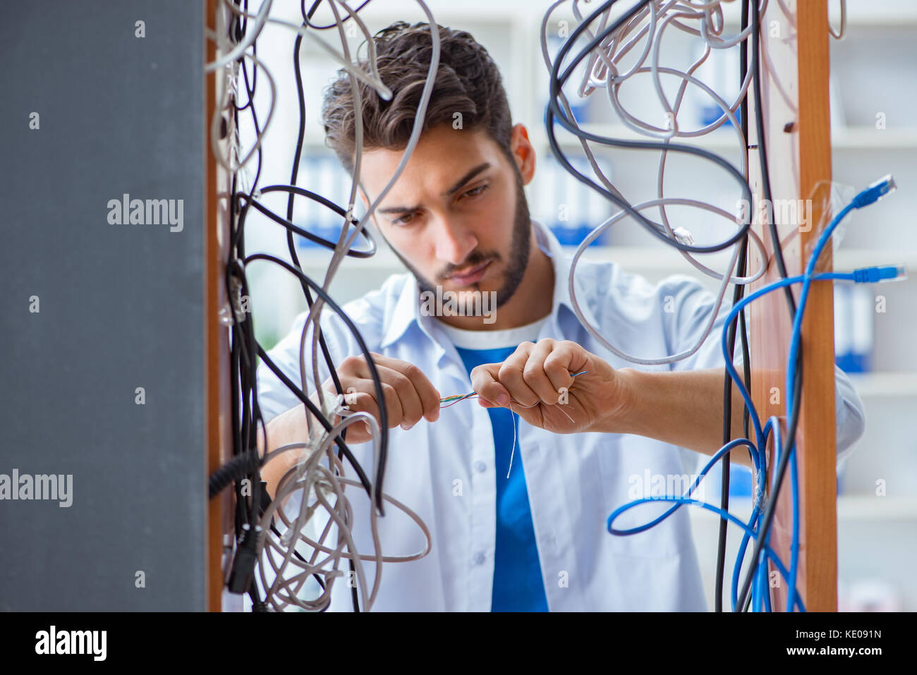 Electrician trying to untangle wires in repair concept Stock Photo - Alamy