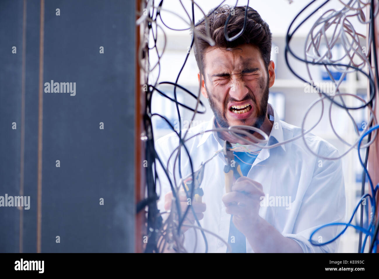 Electrician trying to untangle wires in repair concept Stock Photo - Alamy