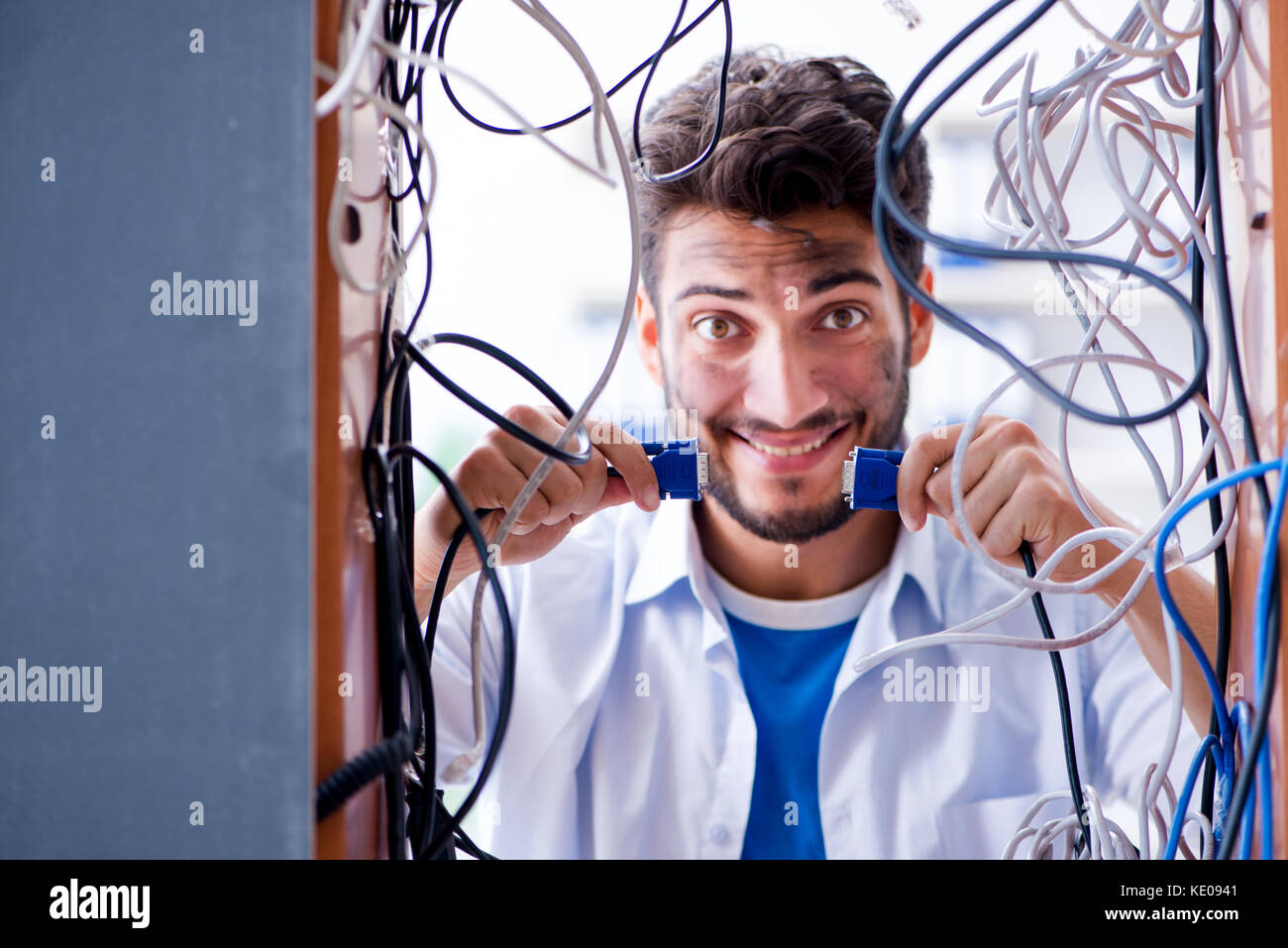 Electrician trying to untangle wires in repair concept Stock Photo - Alamy