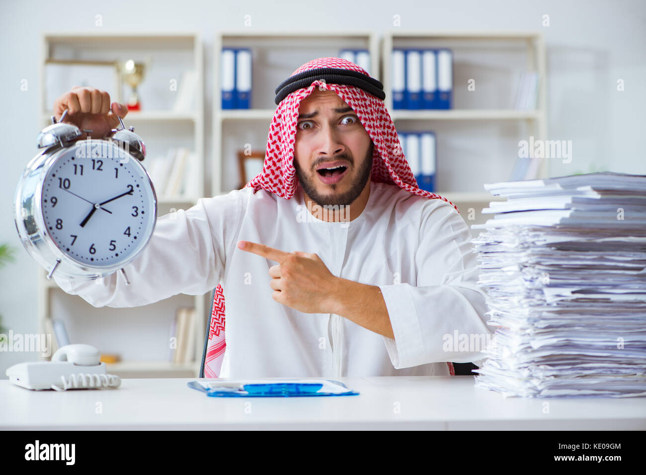 Arab businessman working in the office doing paperwork with a pile of ...