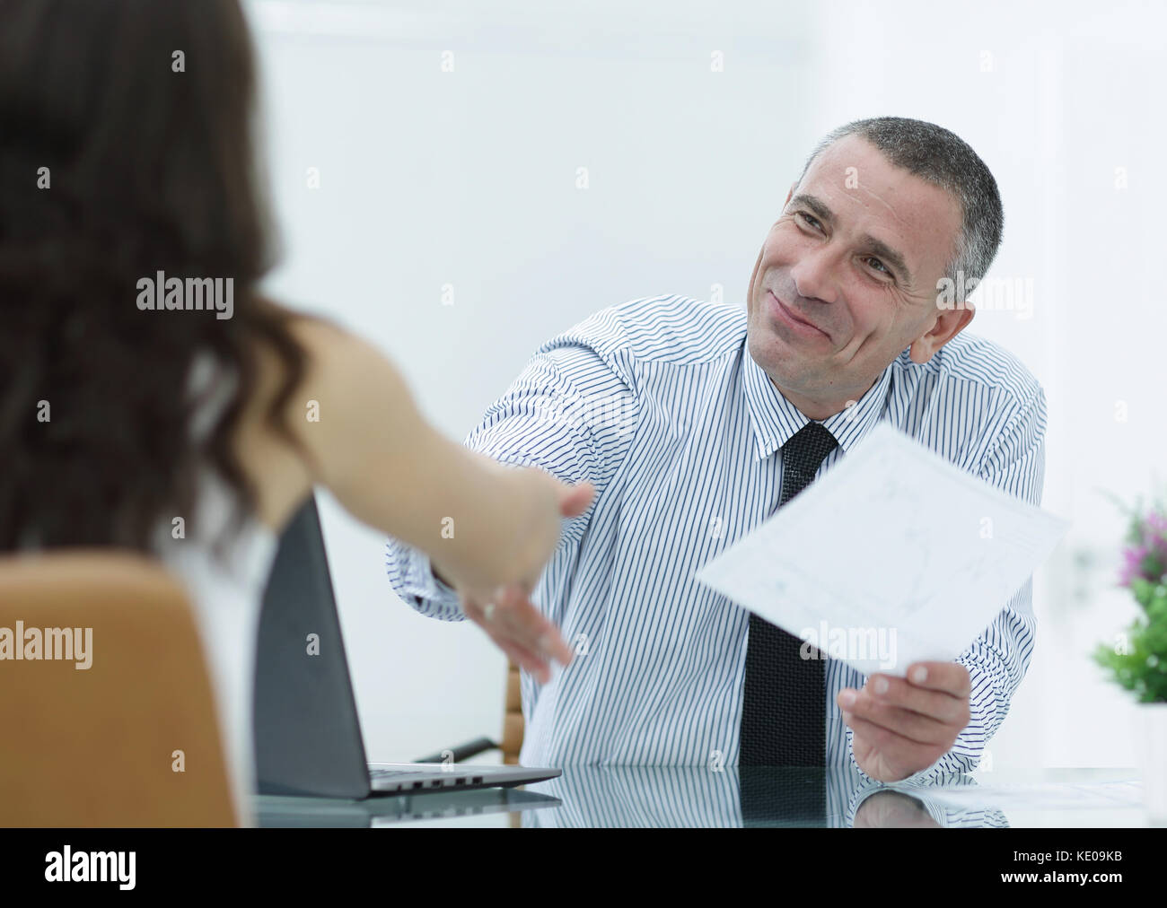 Manager gives the customer a signed contract Stock Photo - Alamy