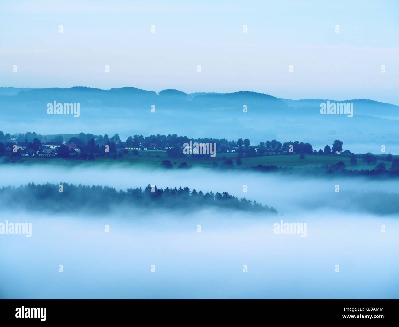 Cold misty blue morning. A minute before sunrise in a beautiful valley ...