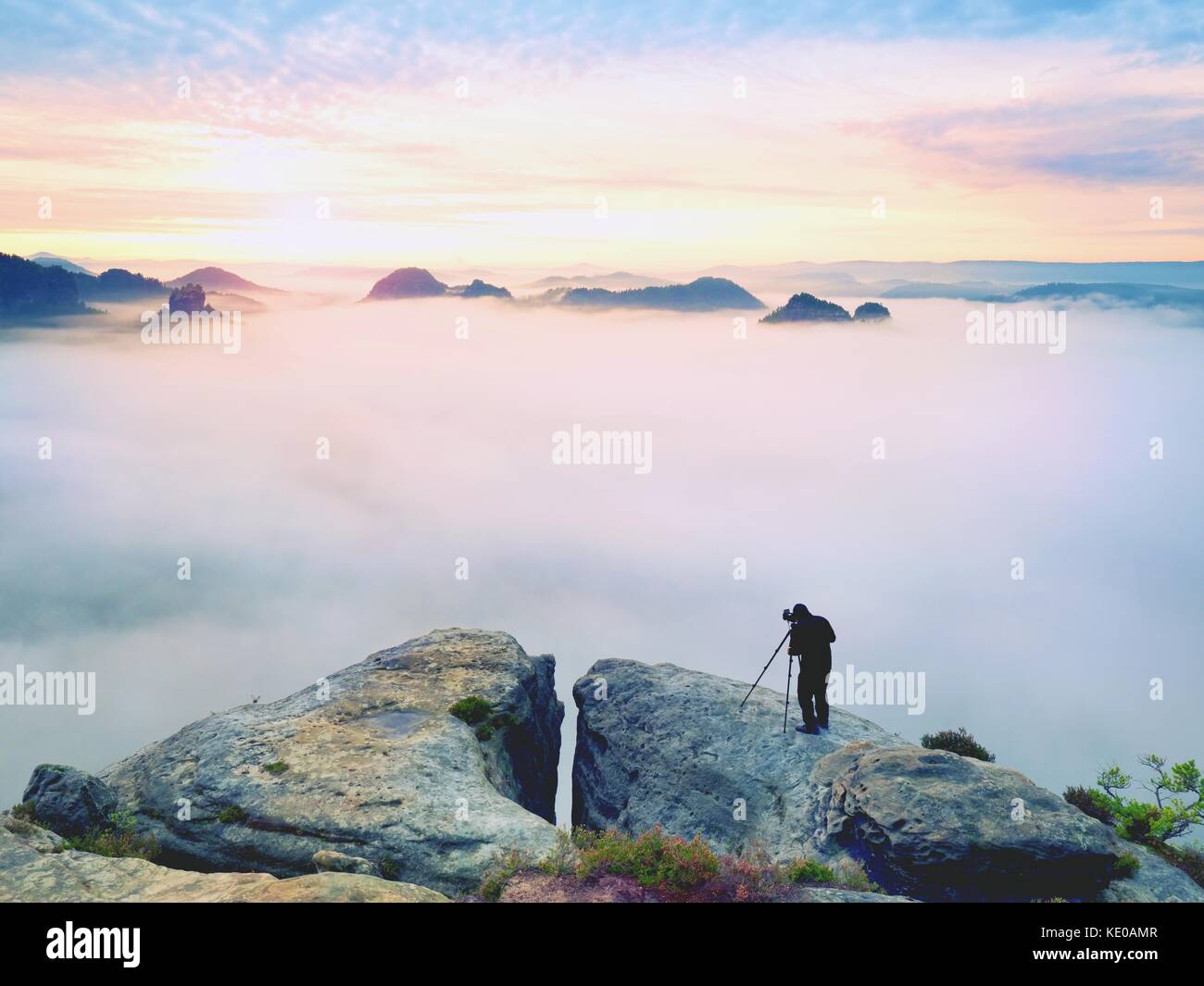 Professional on cliff. Nature photographer takes photos with mirror ...