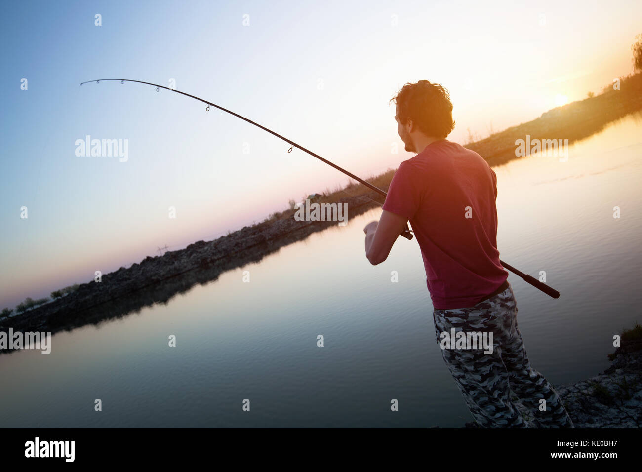 Men fishing in sunset and relaxing while enjoying hobby Stock Photo - Alamy