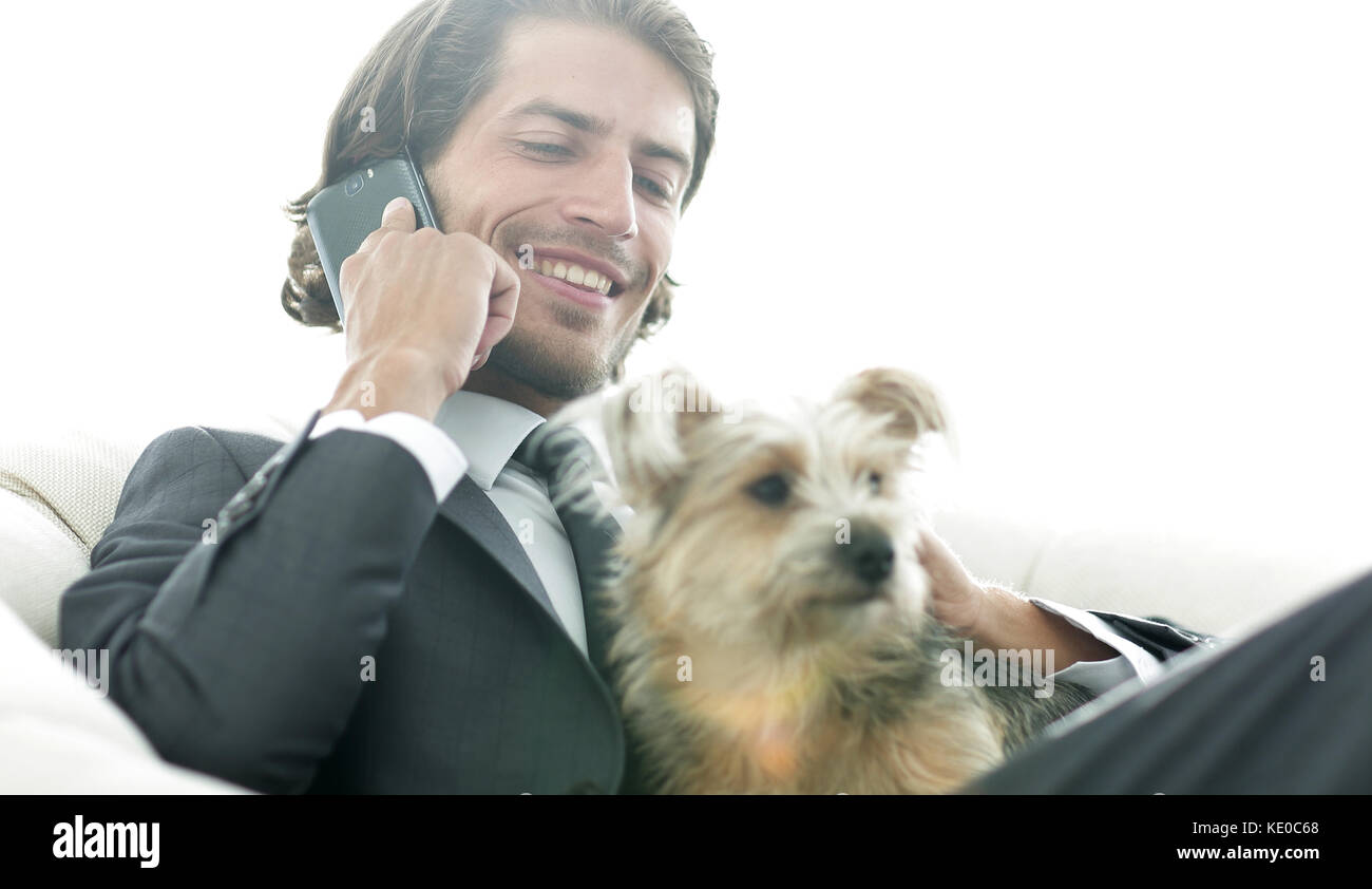 close-up of a businessman talking on the phone and holding his pet ...