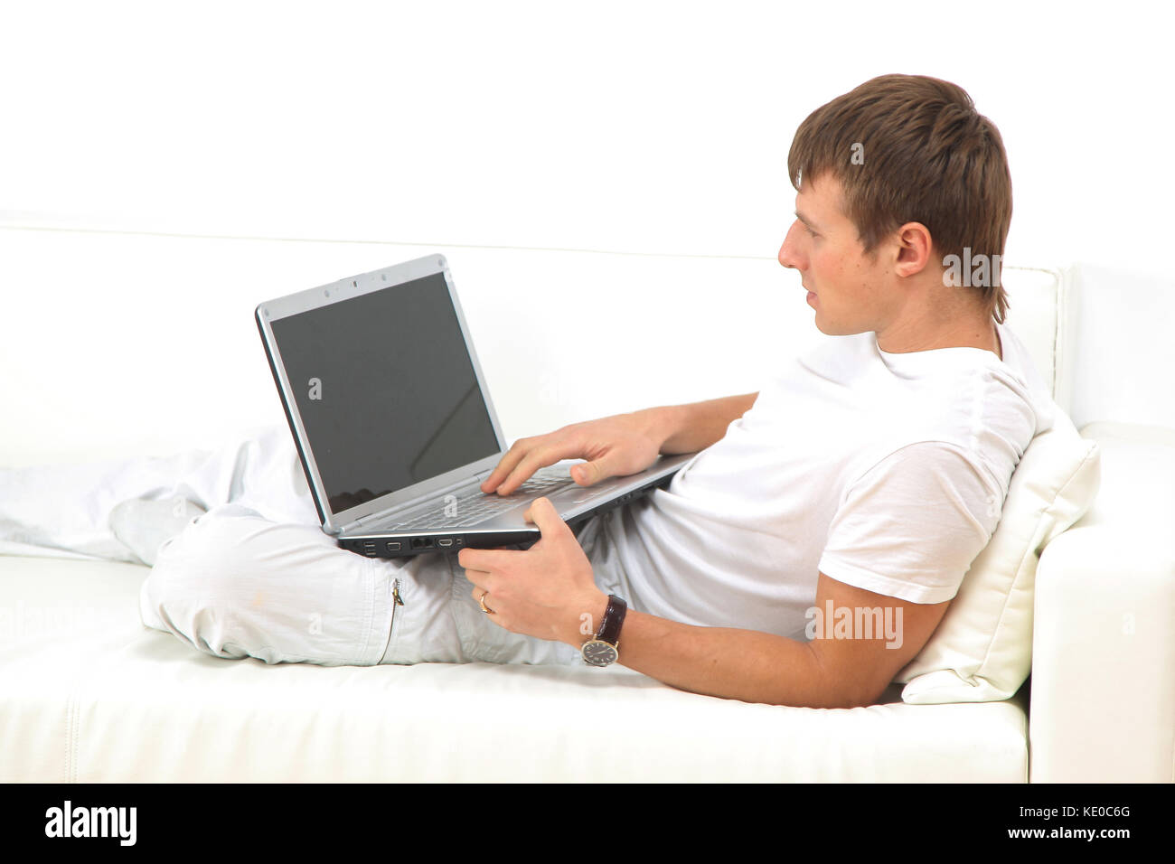 Very focused young man using laptop while sitting comfortably Stock ...