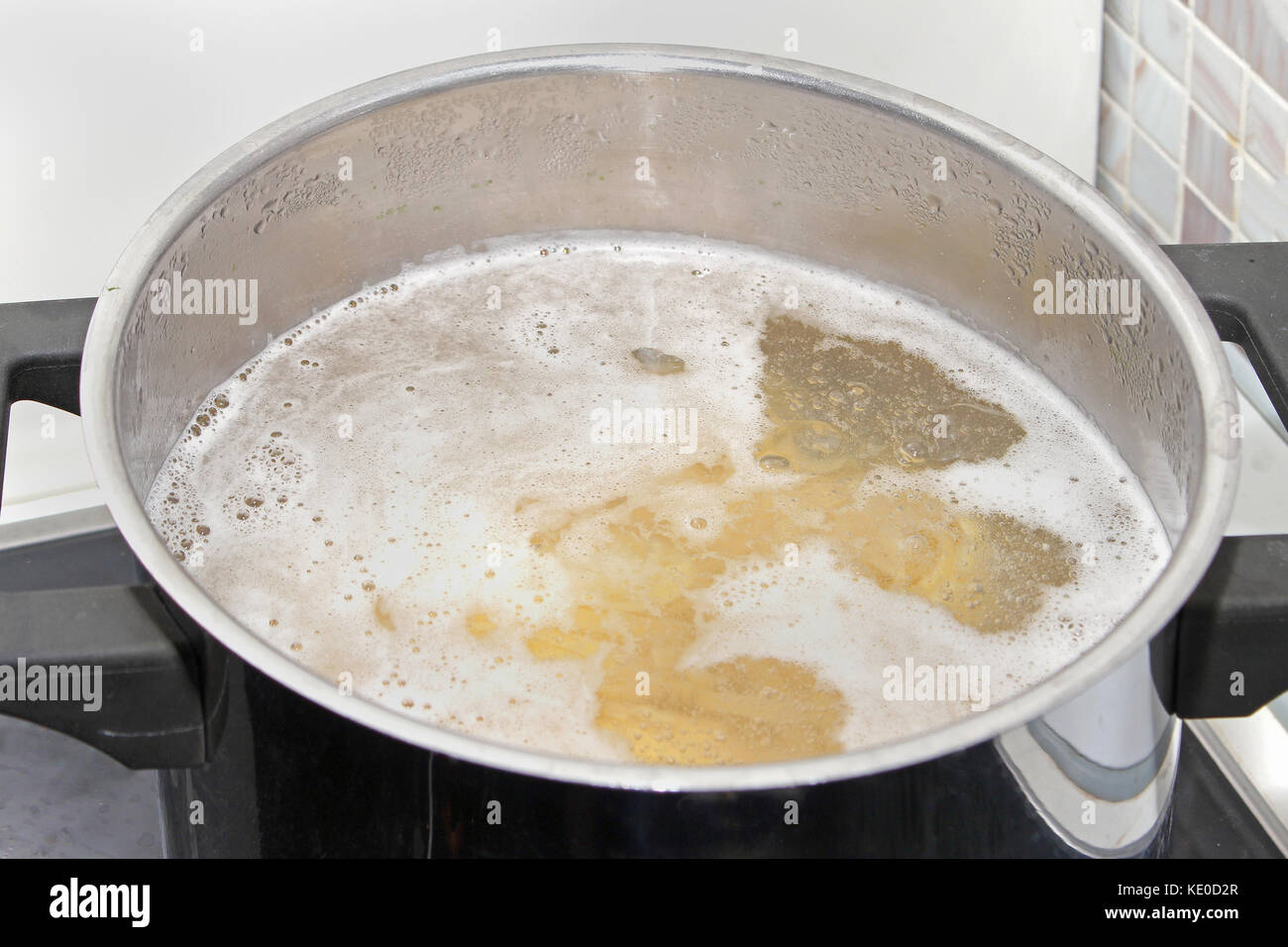 Pasta cooking in boiling water in silver container Stock Photo - Alamy