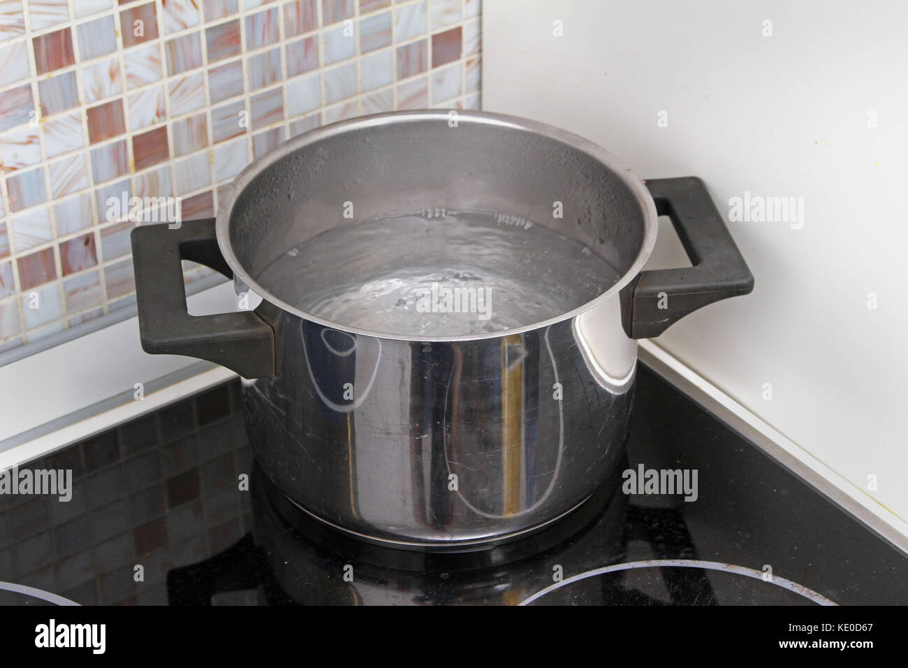 Water boiling in a pot on stove in modern kitchen Stock Photo - Alamy