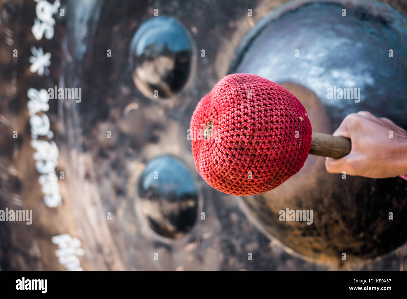 Hand hit big gong in temple Stock Photo - Alamy