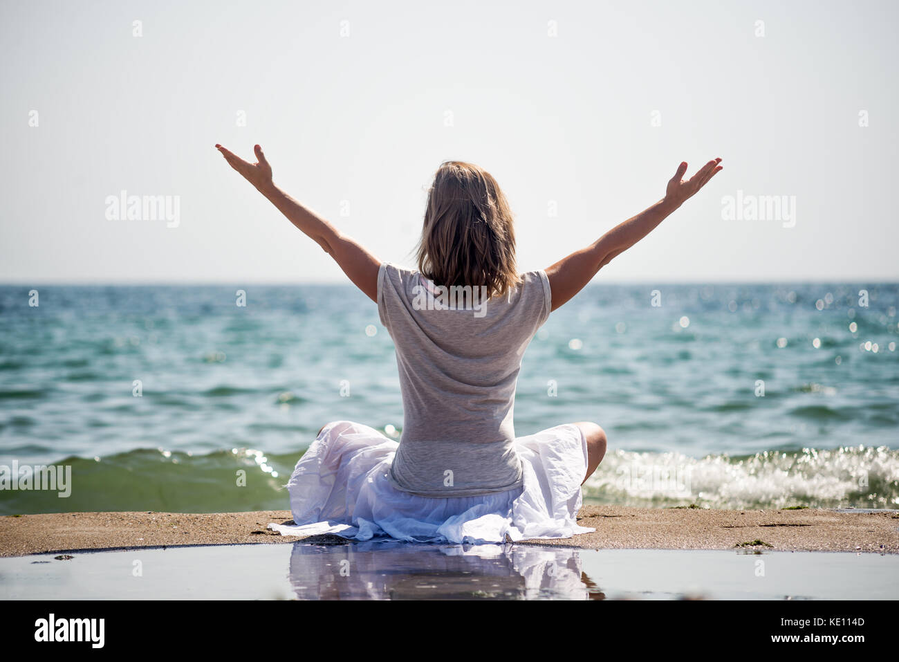 Woman meditating at the sea Stock Photo - Alamy