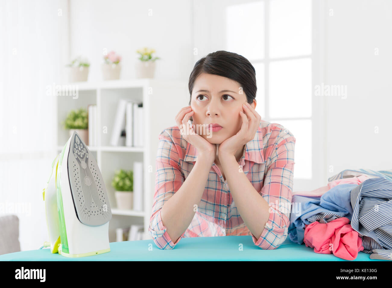 pretty elegant housewife ironing clothing feeling boring and leaning on ...