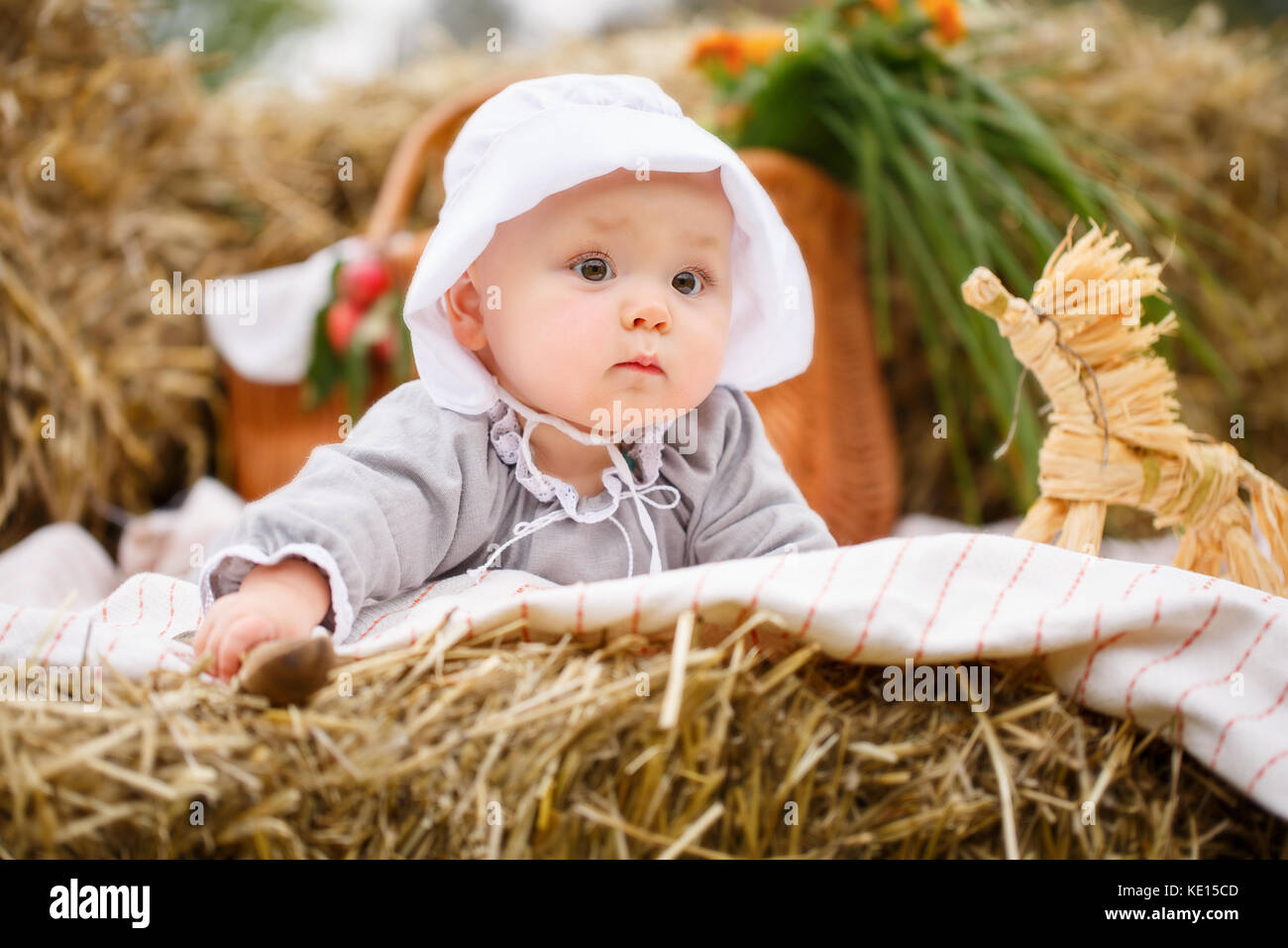 Happy baby in a field with hay rolls at sunset. lies on the hay Stock ...