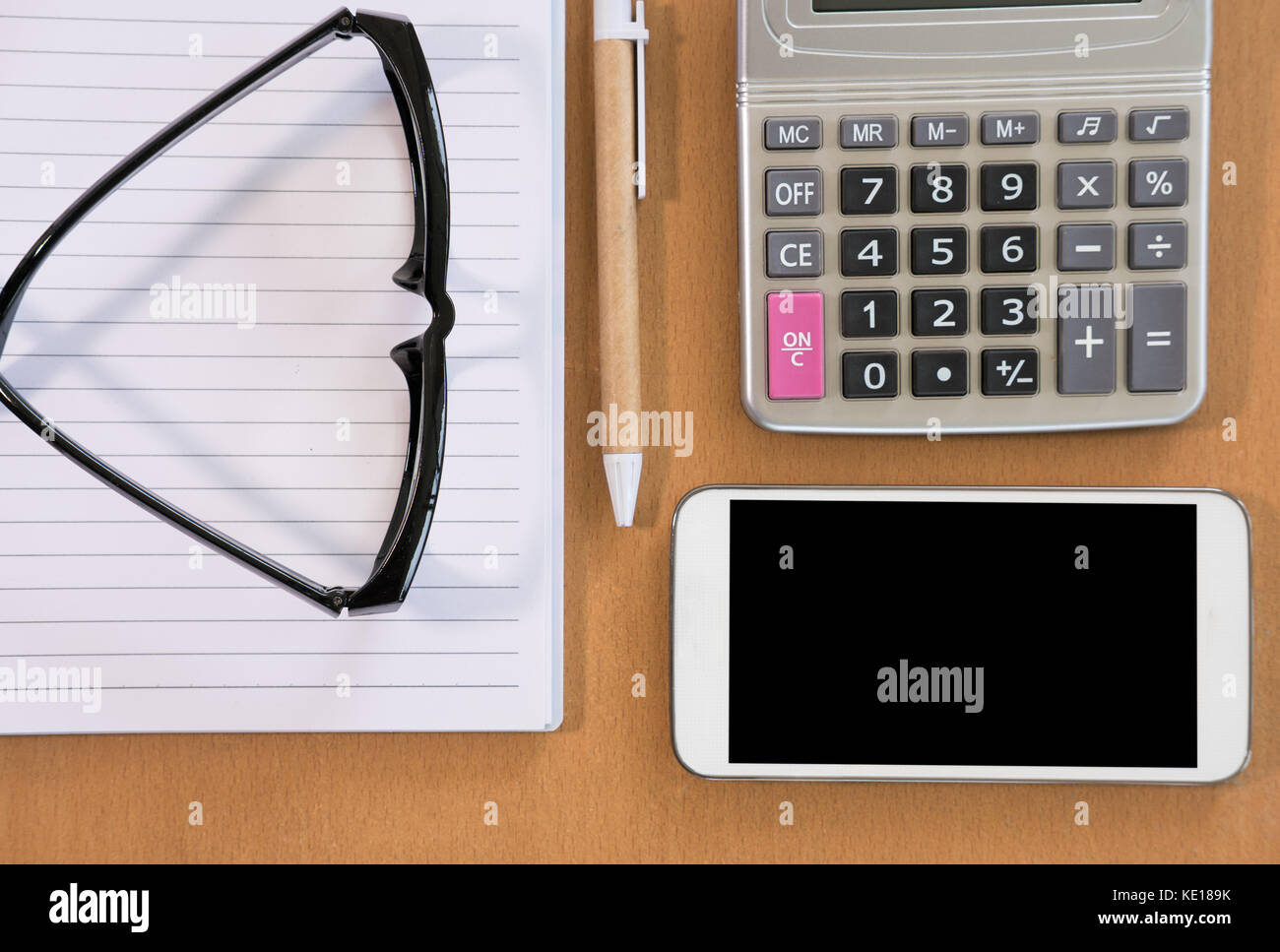smart phone, calculator, ballpoint pen, empty notebook, eyeglasses on ...