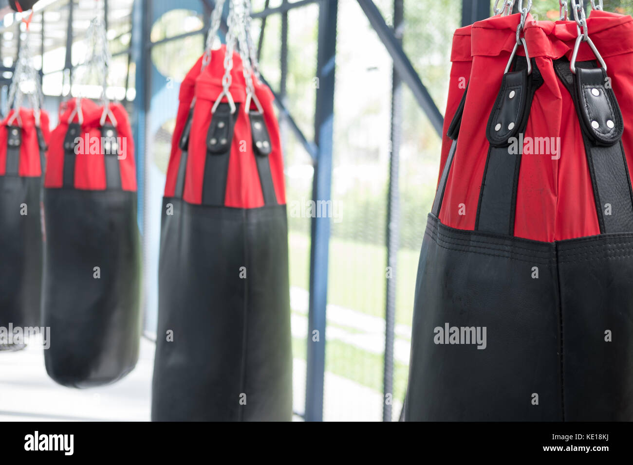 red and black sandbag for hitting and punching in boxing gym. sport ...