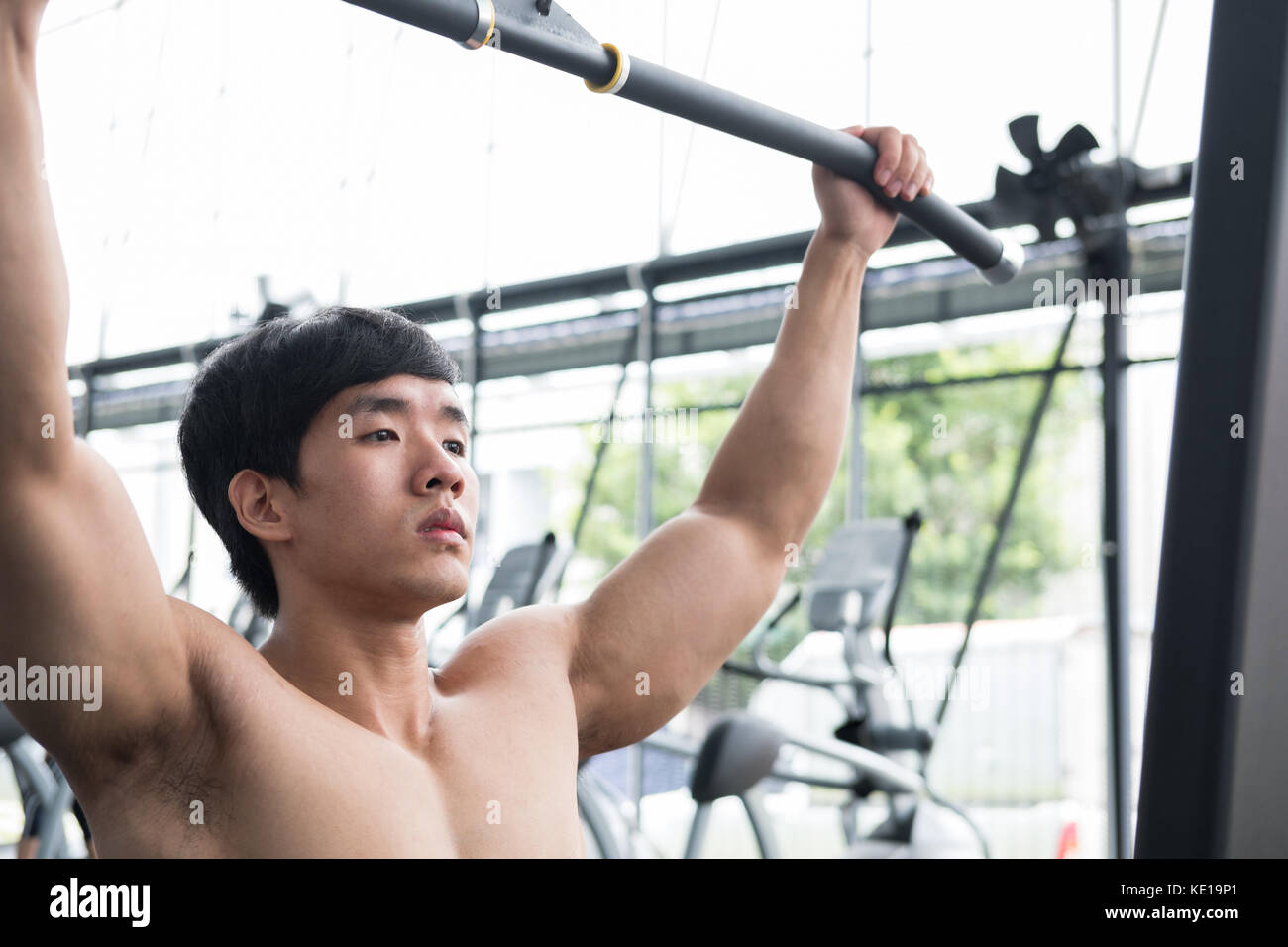 young man execute exercise with weightlifting machine in fitness center ...