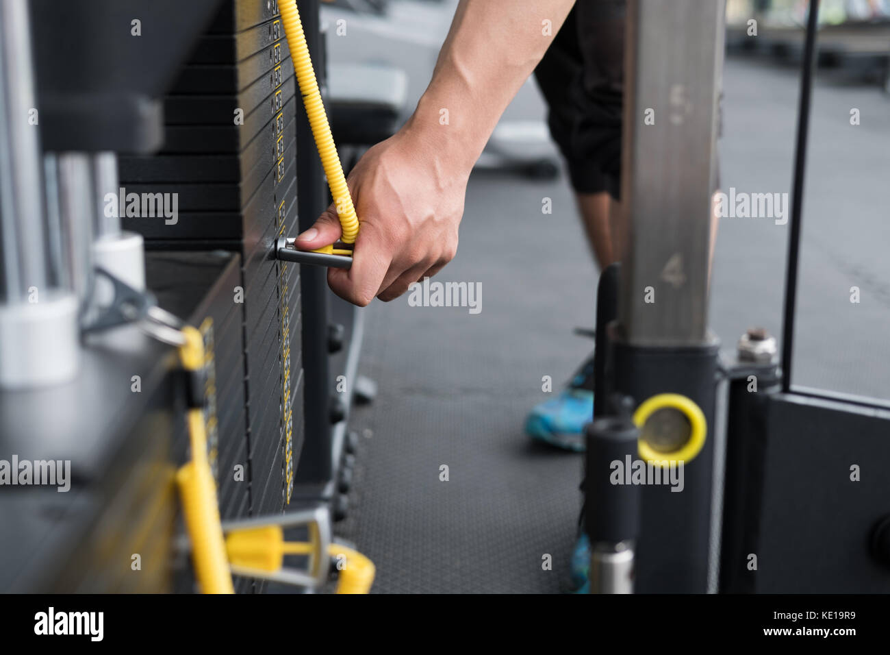 young man execute exercise with pull down machine in fitness center ...