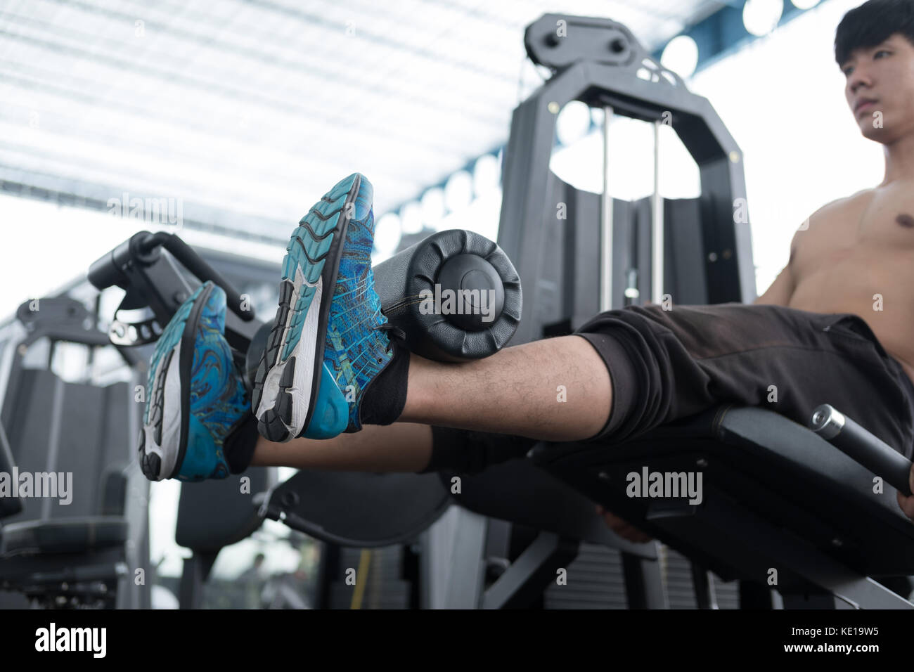 young man execute exercise with weightlifting machine in fitness center ...