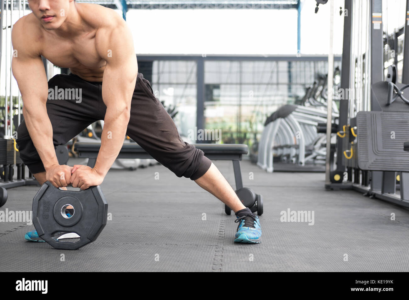 young man bodybuilder execute exercise in fitness center. male athlete ...