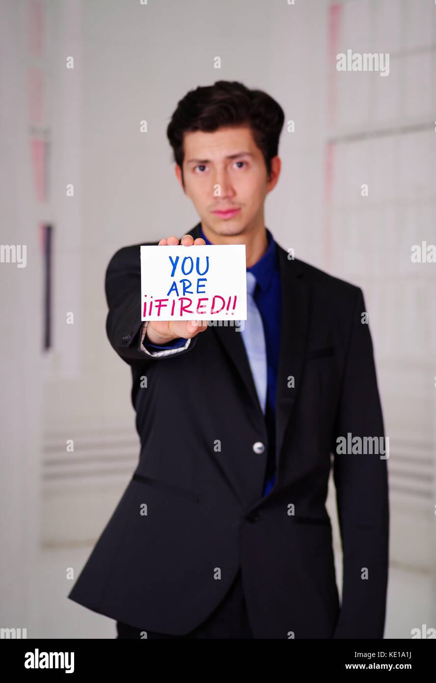 Sad business man hold paper you're fired text on it, in a blurred ...