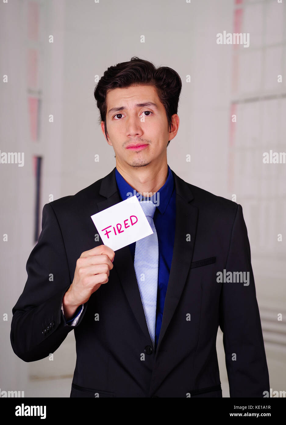 Sad business man holding a paper of fired text on it in his hand, in a ...