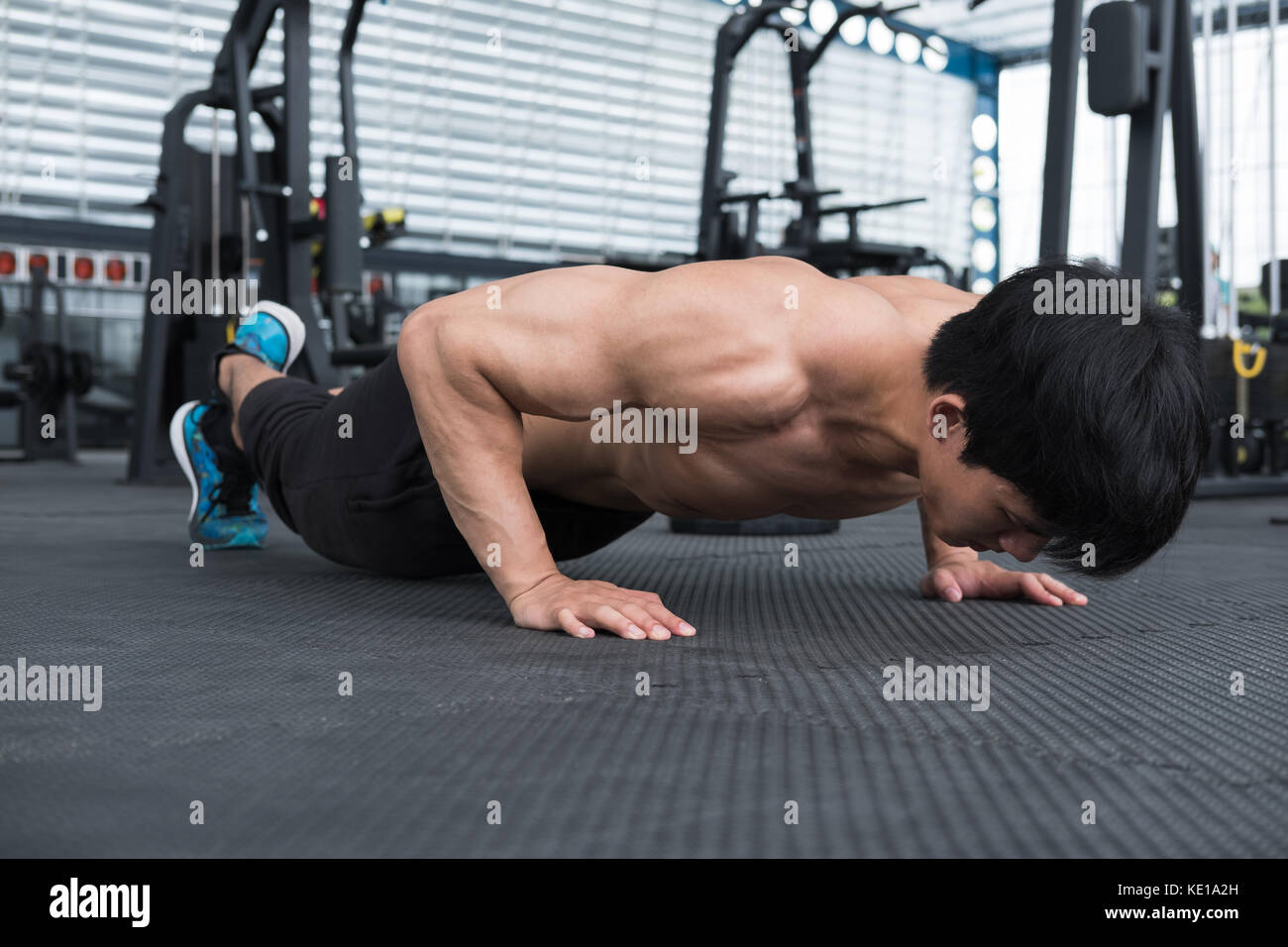 young muscle man doing push ups in gym. bodybuilder male working out in ...