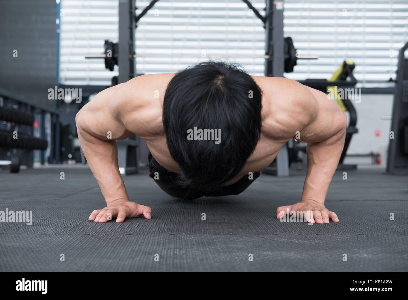 young muscle man doing push ups in gym. bodybuilder male working out in ...