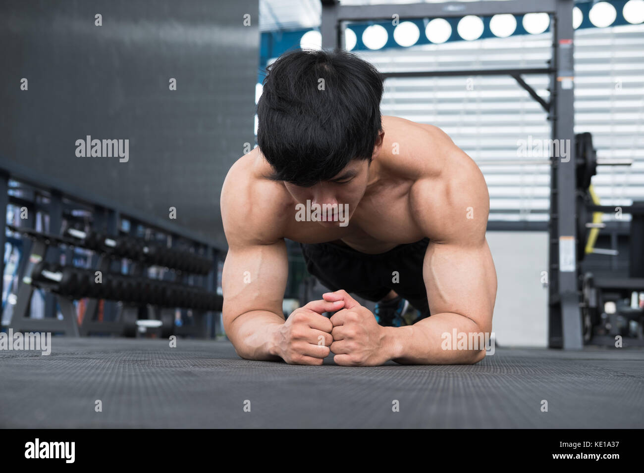 young muscle man doing plank position in gym. bodybuilder male working ...
