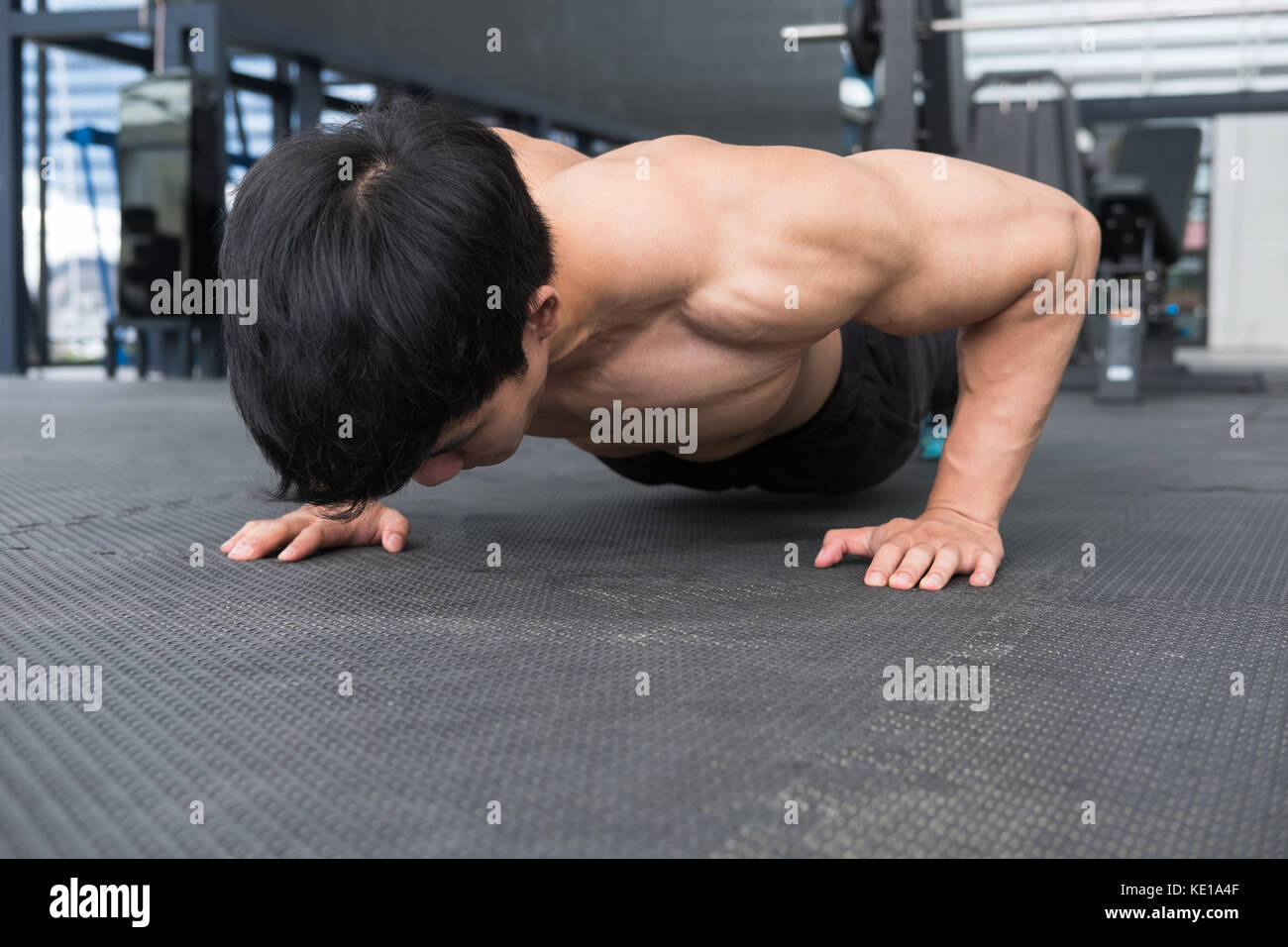 young muscle man doing push ups in gym. bodybuilder male working out in ...