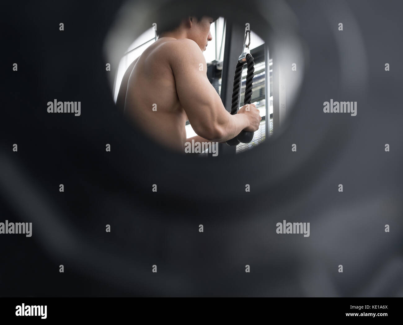 young man execute exercise with weightlifting machine in fitness center ...