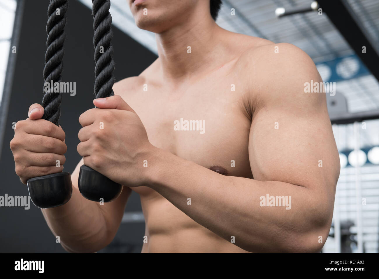 young man execute exercise with weightlifting machine in fitness center ...