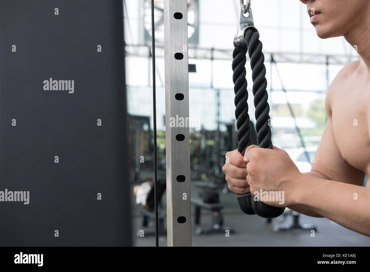 young man execute exercise with weightlifting machine in fitness center ...