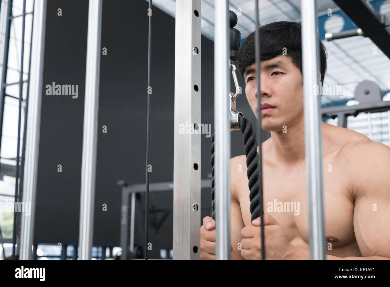young man execute exercise with weightlifting machine in fitness center ...