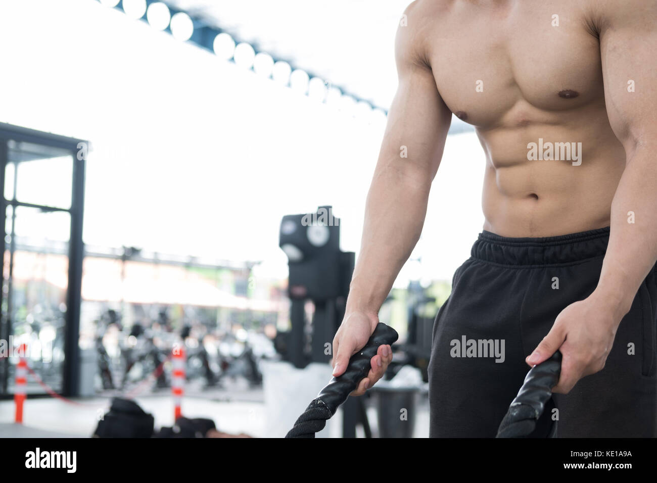 young man execute exercise in fitness center. male athlete training ...