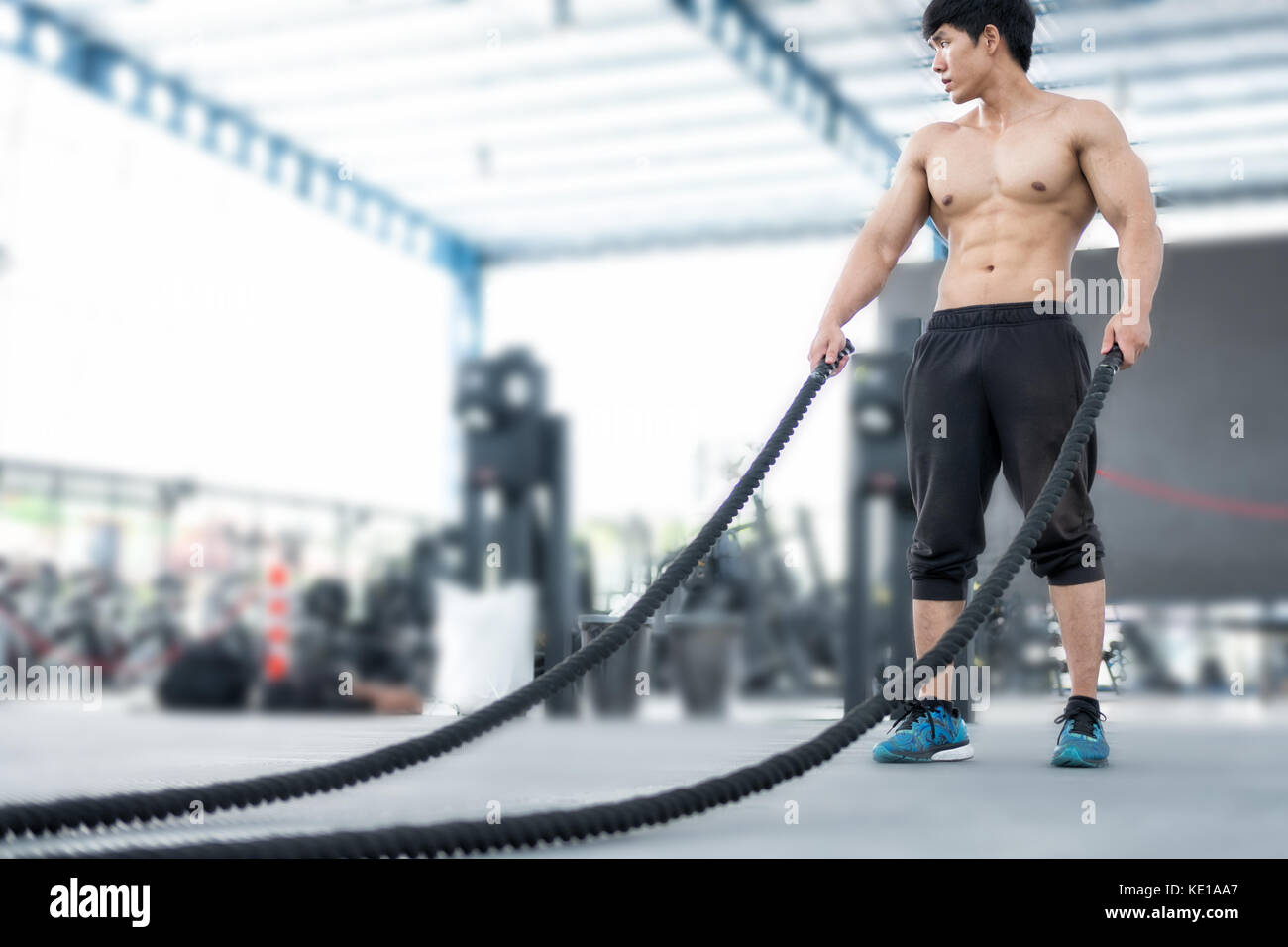 young man execute exercise in fitness center. male athlete training ...