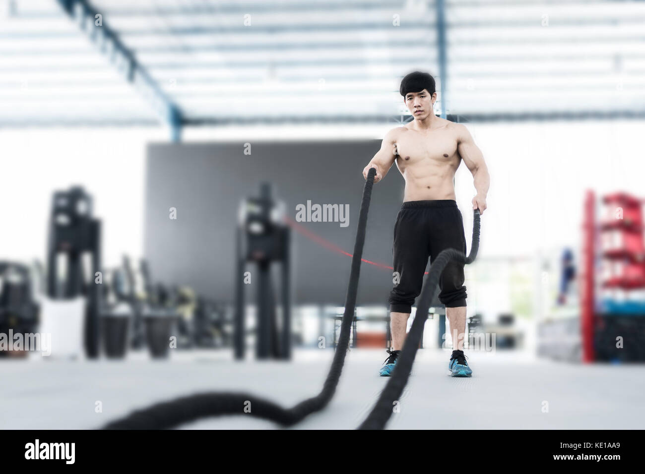 young man execute exercise in fitness center. male athlete training ...