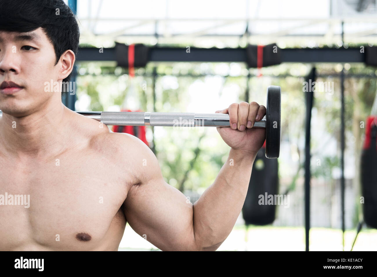 young muscular man execute exercise in fitness center. male athlete ...