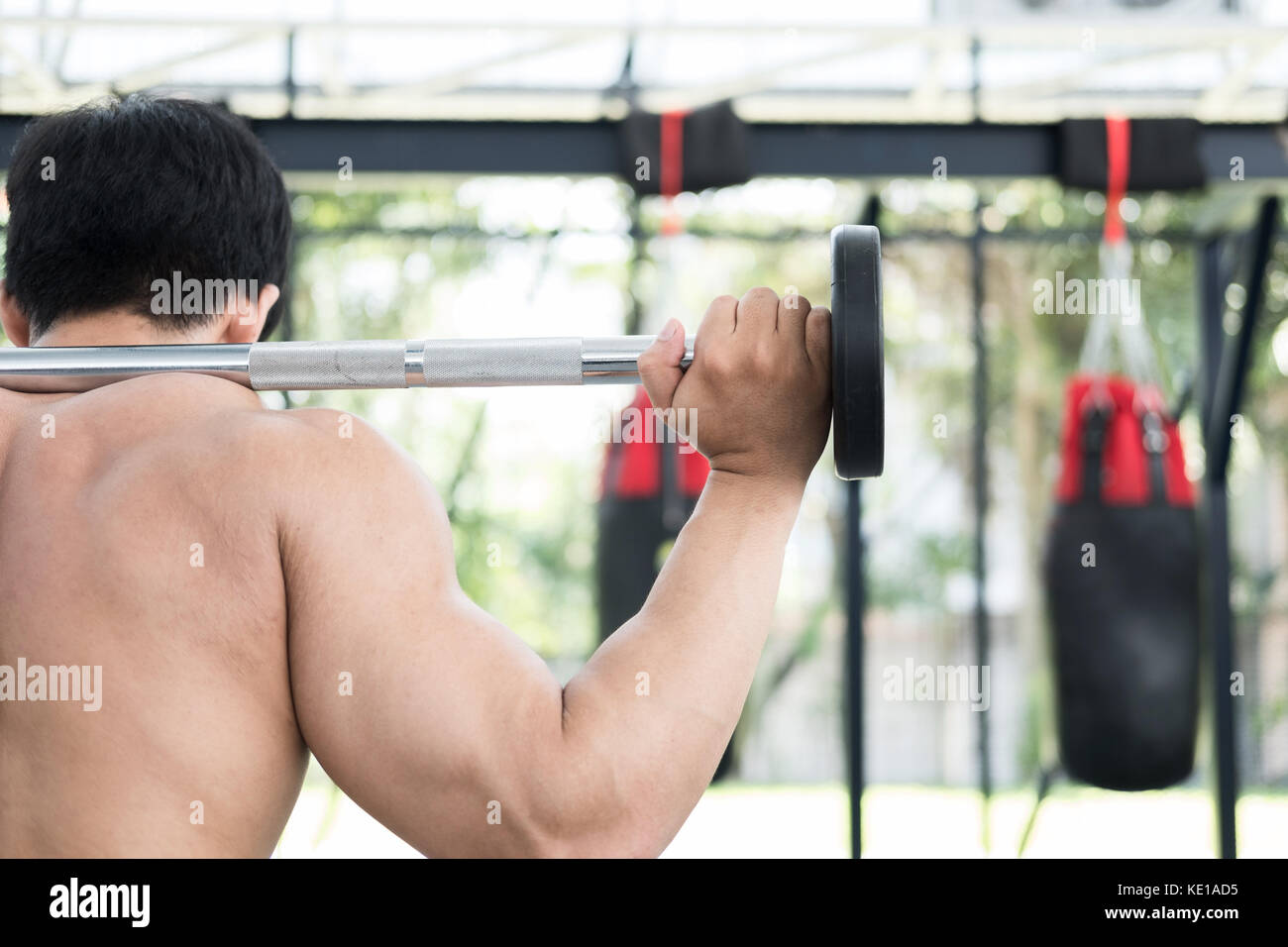 young muscular man execute exercise in fitness center. male athlete ...