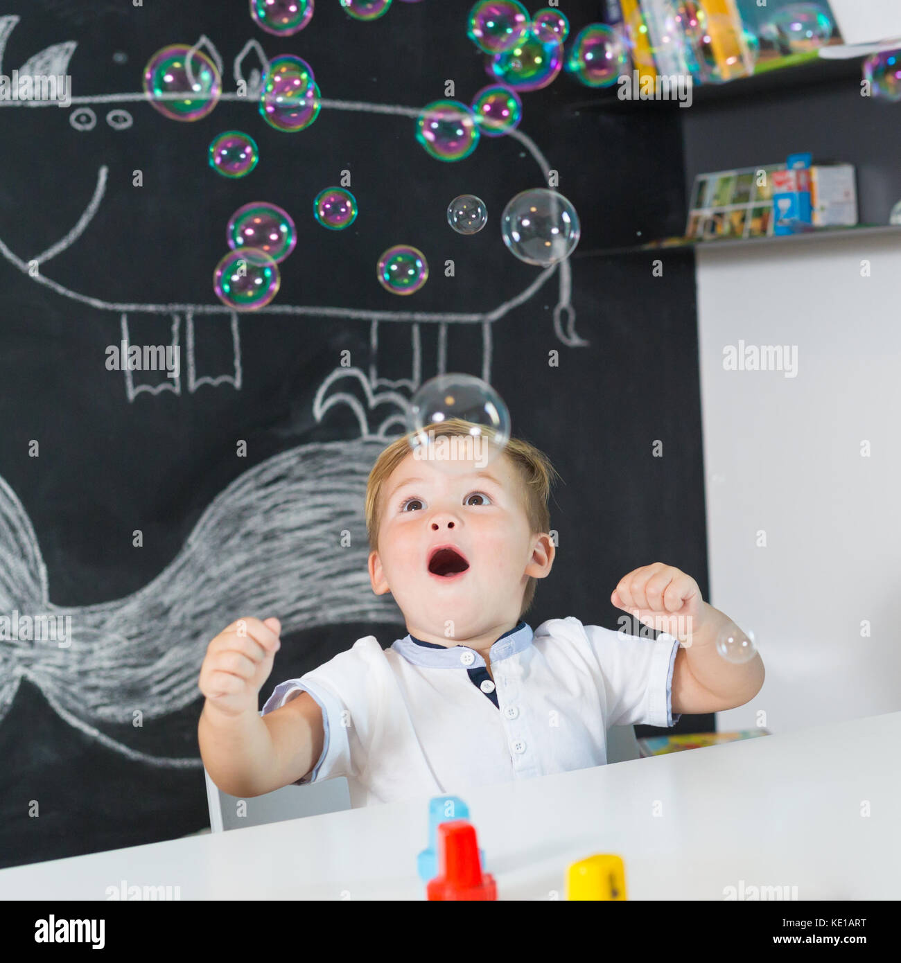 Portrait of cute toddler boy amazed by milky bubbles Stock Photo - Alamy