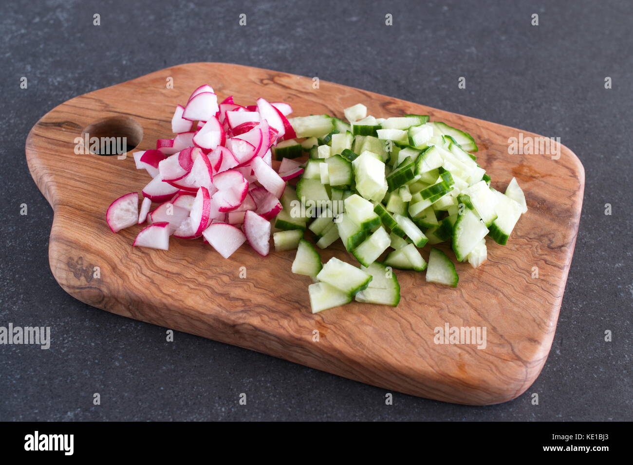 Cut radish and cucumbers on an olive wood cutting board Stock Photo - Alamy