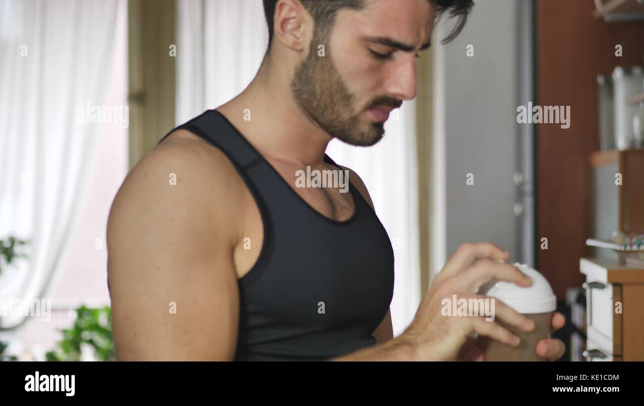 Young man drinking a smoothie drink or a protein shake Stock Photo - Alamy