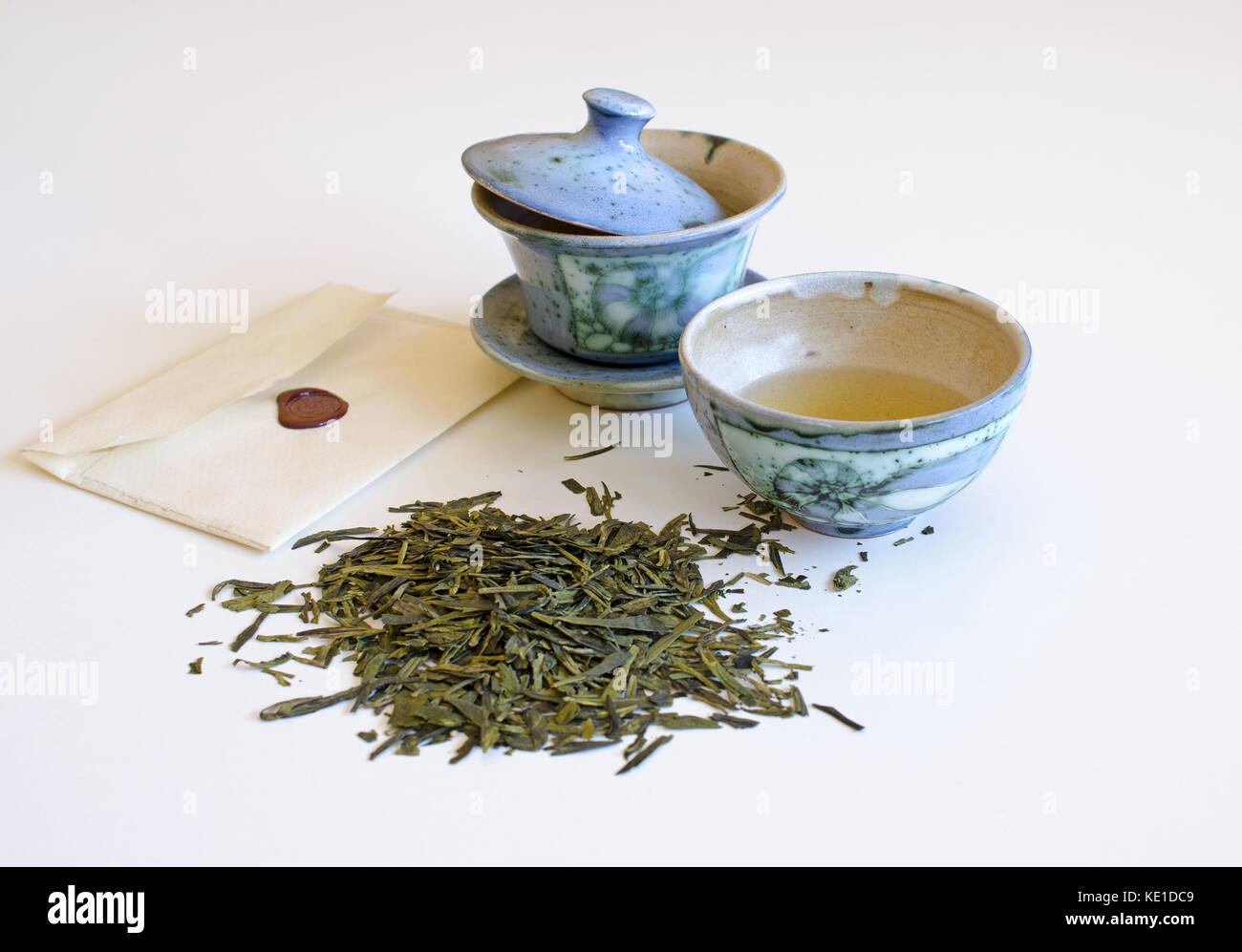 Cup of tea with tea leaves and scattered pile, isolated on a white ...