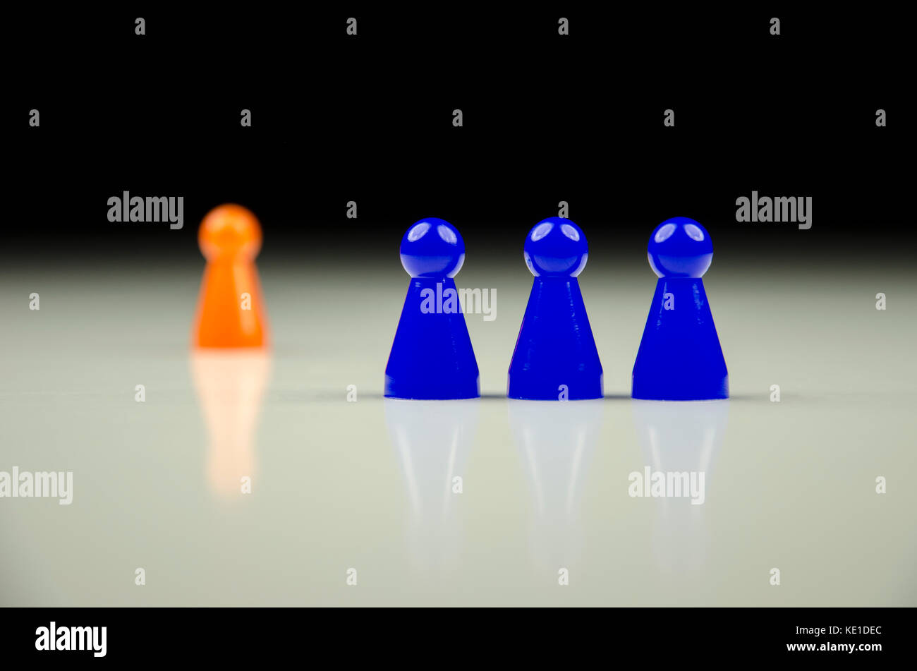 Close-up view of a row of blue figures with one red figure at the back ...