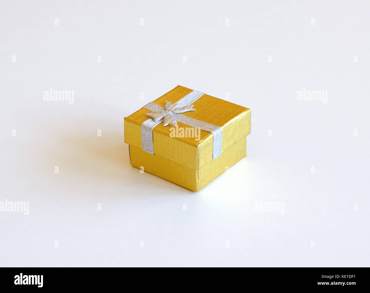 Still life with golden gift box with ribbon isolated on white ...