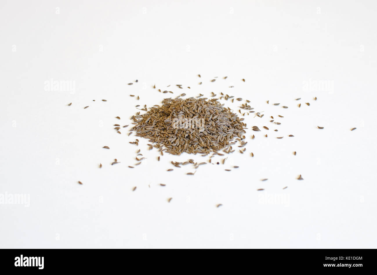 Spilled pile of cumin seeds are isolated on a white background Stock ...