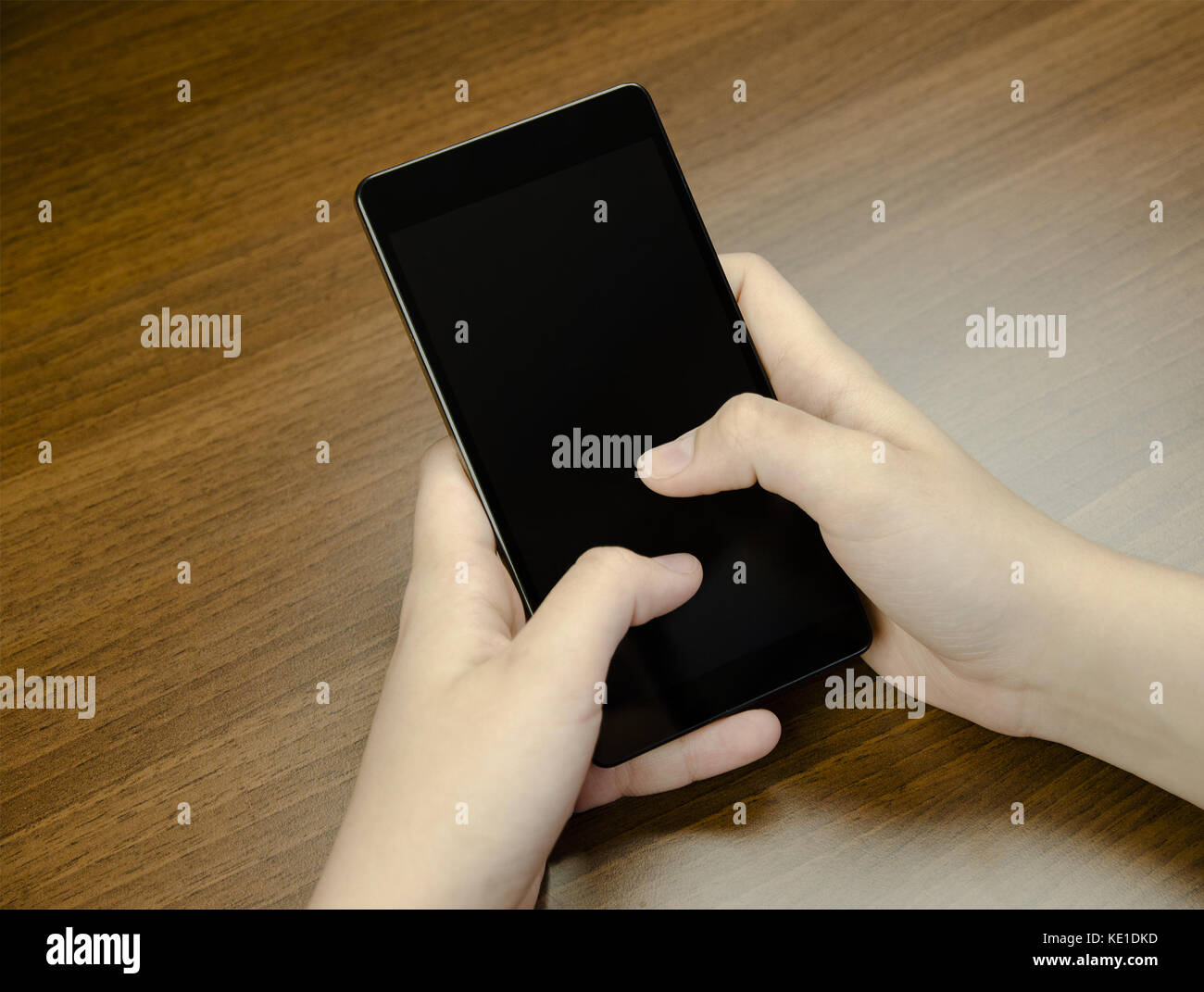 Closeup view of a hand with fingers holding a black cell phone with ...