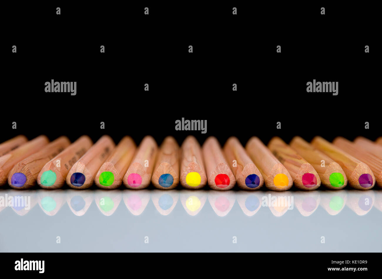 Close-up view of colored pencils lying on glossy white background with ...