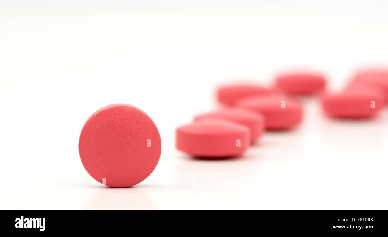 Close-up photo of pink orange pills isolated on white background with ...