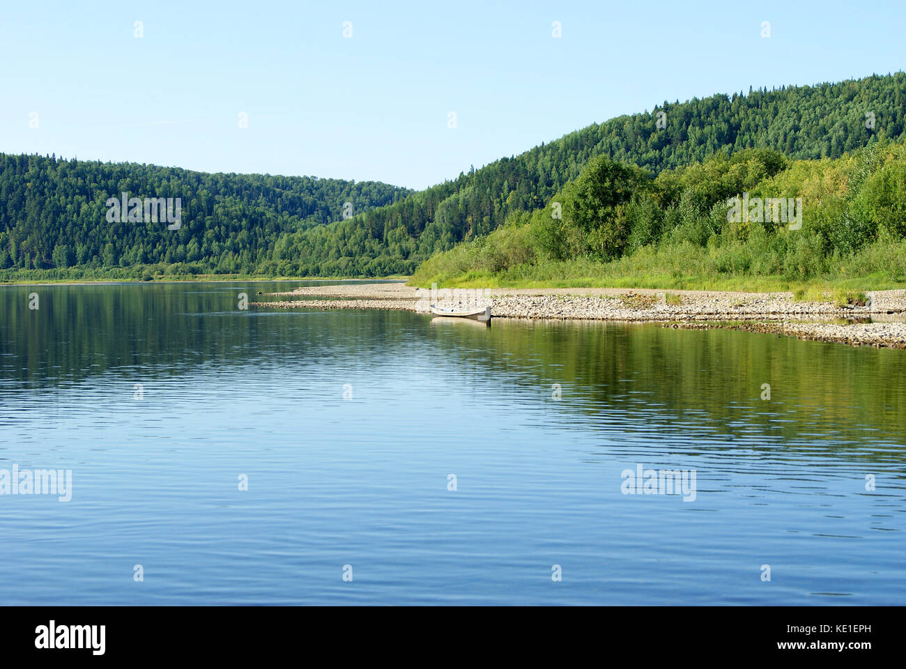 View from the water to the Ural river Vishera with a fishing boat on ...