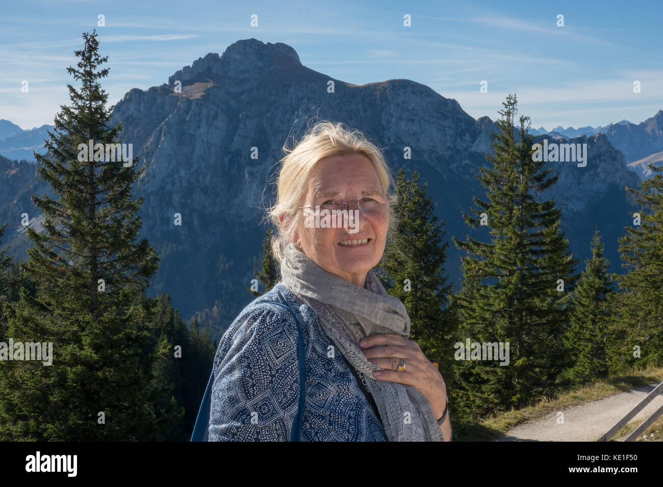 European woman in the Bavarian Alps with clear blue skies and sunshine ...